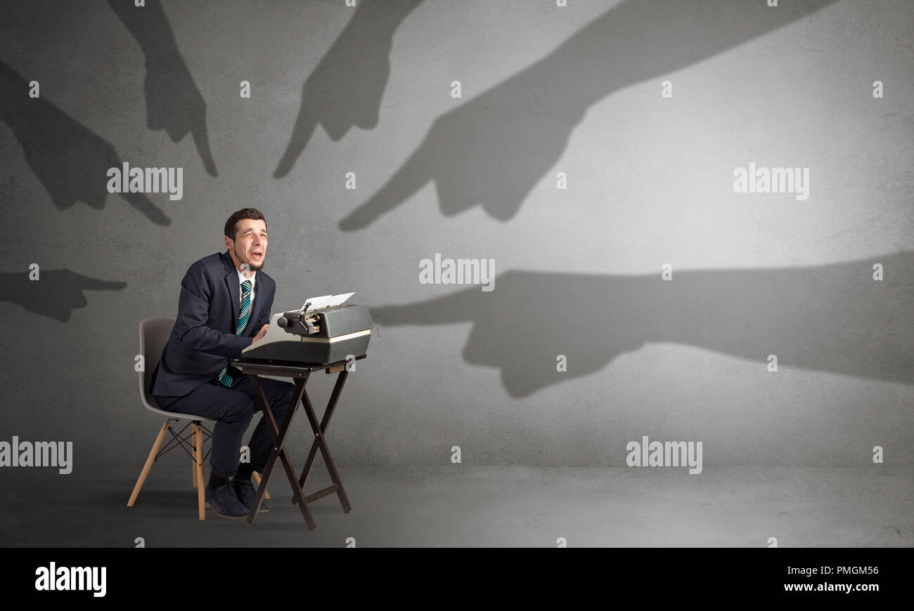 Shadow hand pointing at a small afraid worker Stock Photo - Alamy