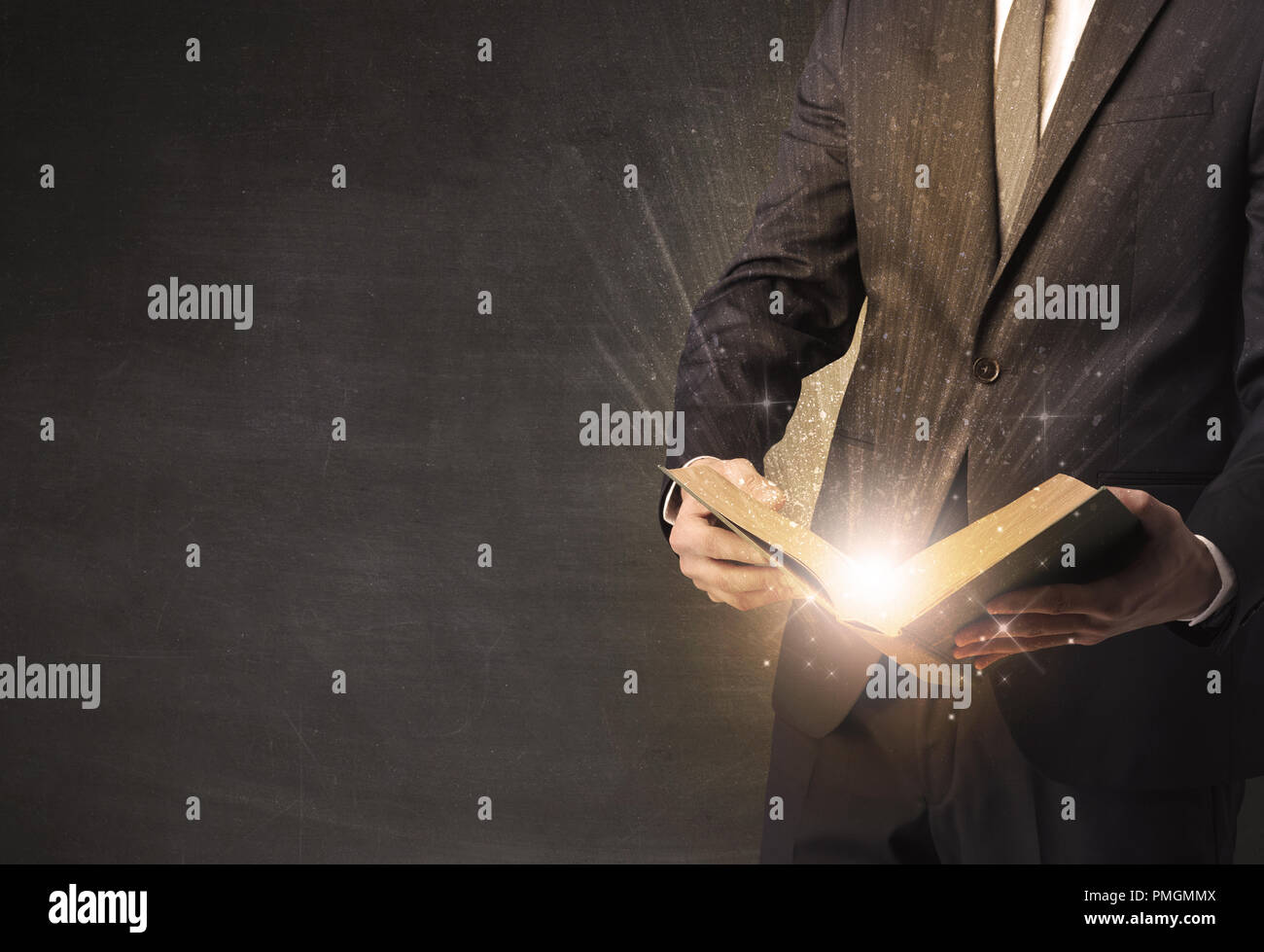 Man holding and reading a shiny book Stock Photo - Alamy