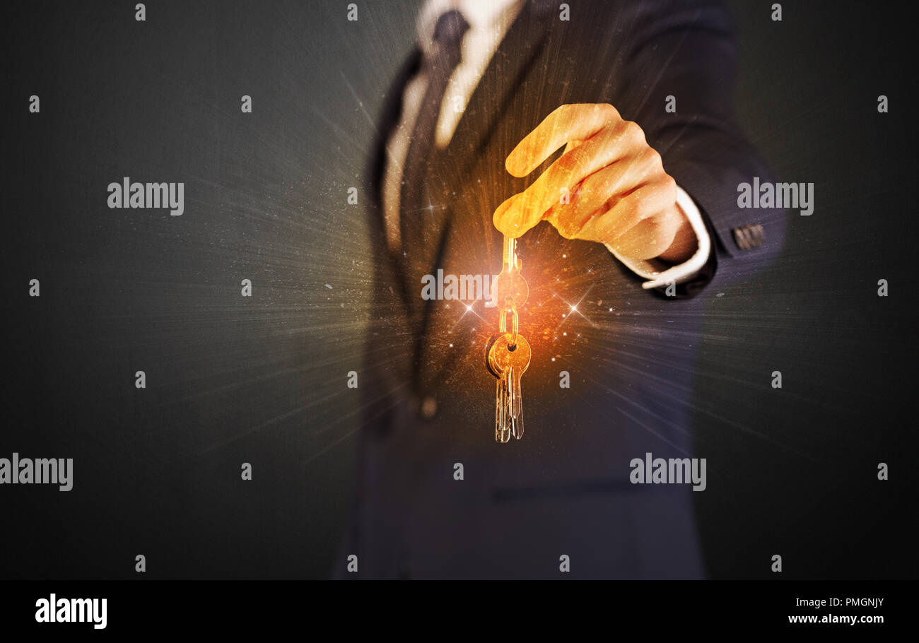 Formal man hand over shiny keys with dark background Stock Photo - Alamy