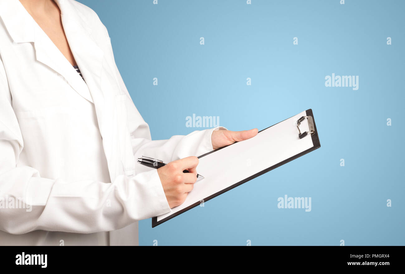 Female doctor holding notepad with blue background Stock Photo - Alamy