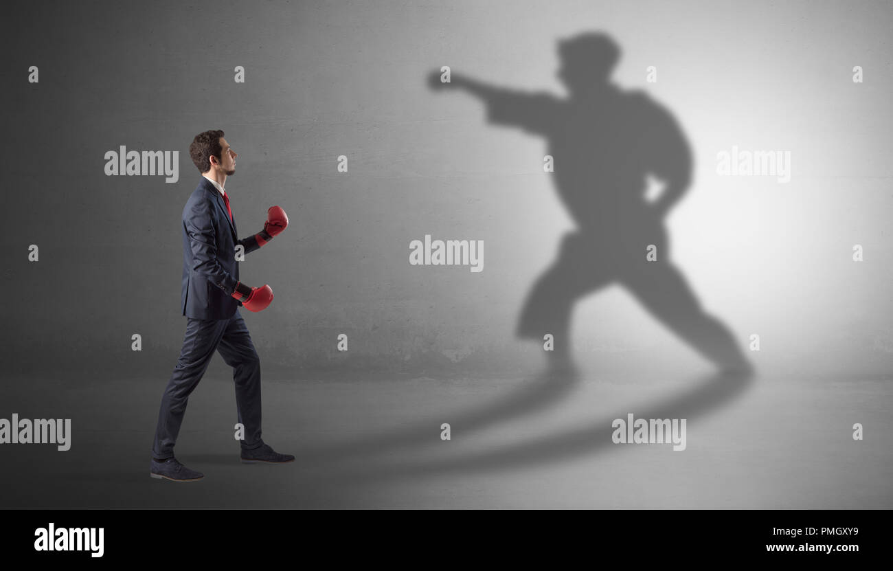 Businessman fighting with his strong karate man shadow Stock Photo - Alamy