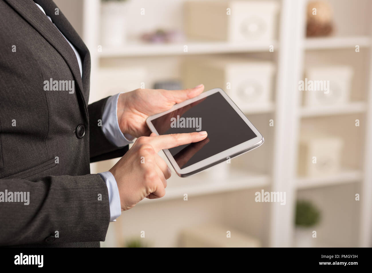 Business woman below chest using tablet in a homey environment Stock ...