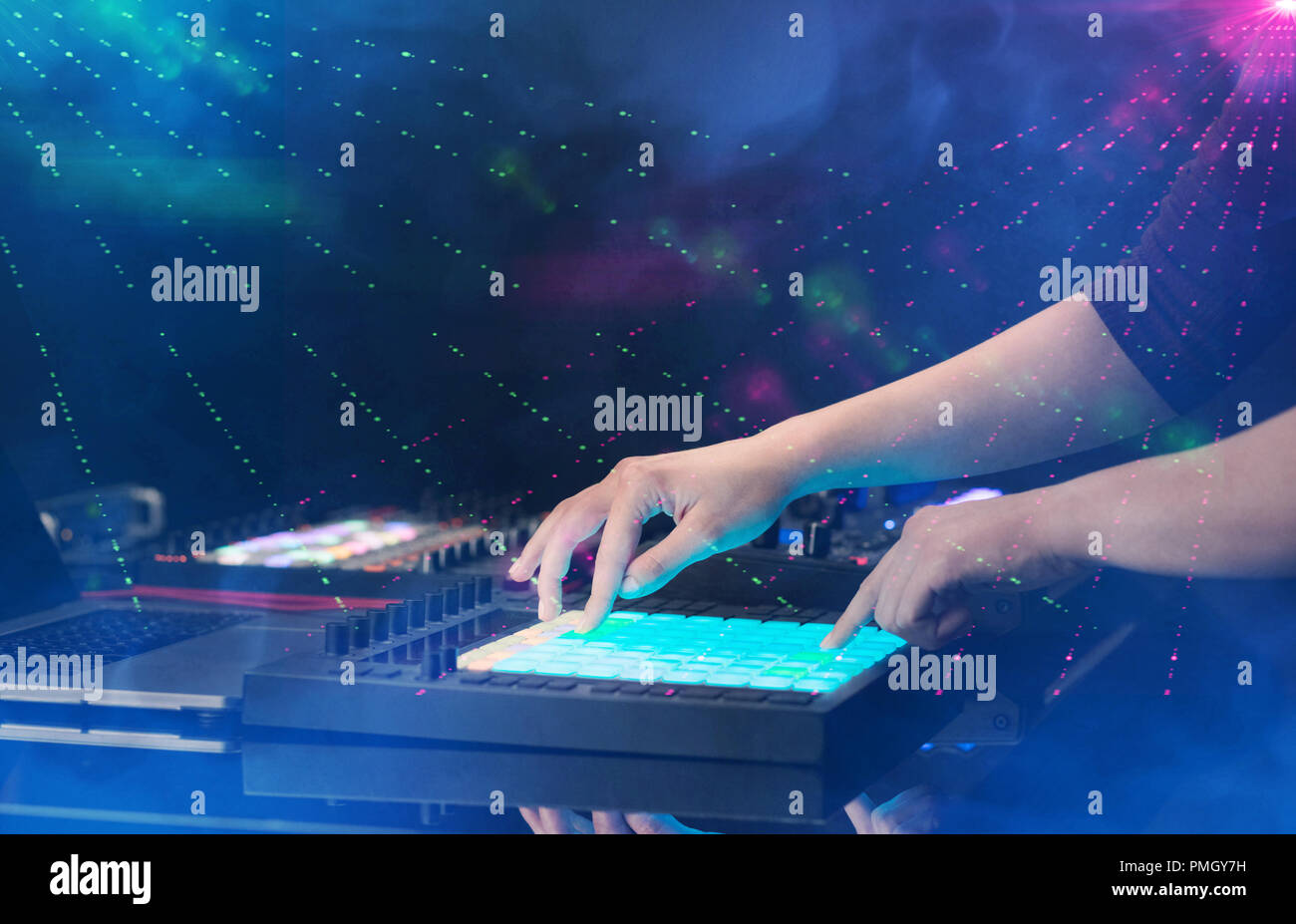 Hand mixing music on dj controller with party club colors around Stock ...