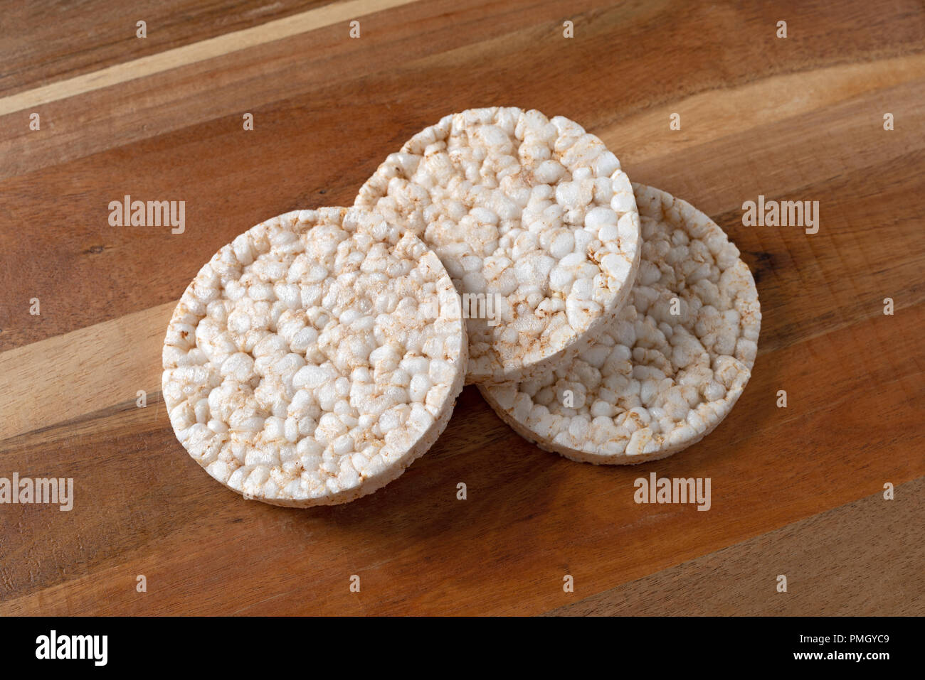 Three multigrain rice cakes on a wood cutting board at an angle Stock ...