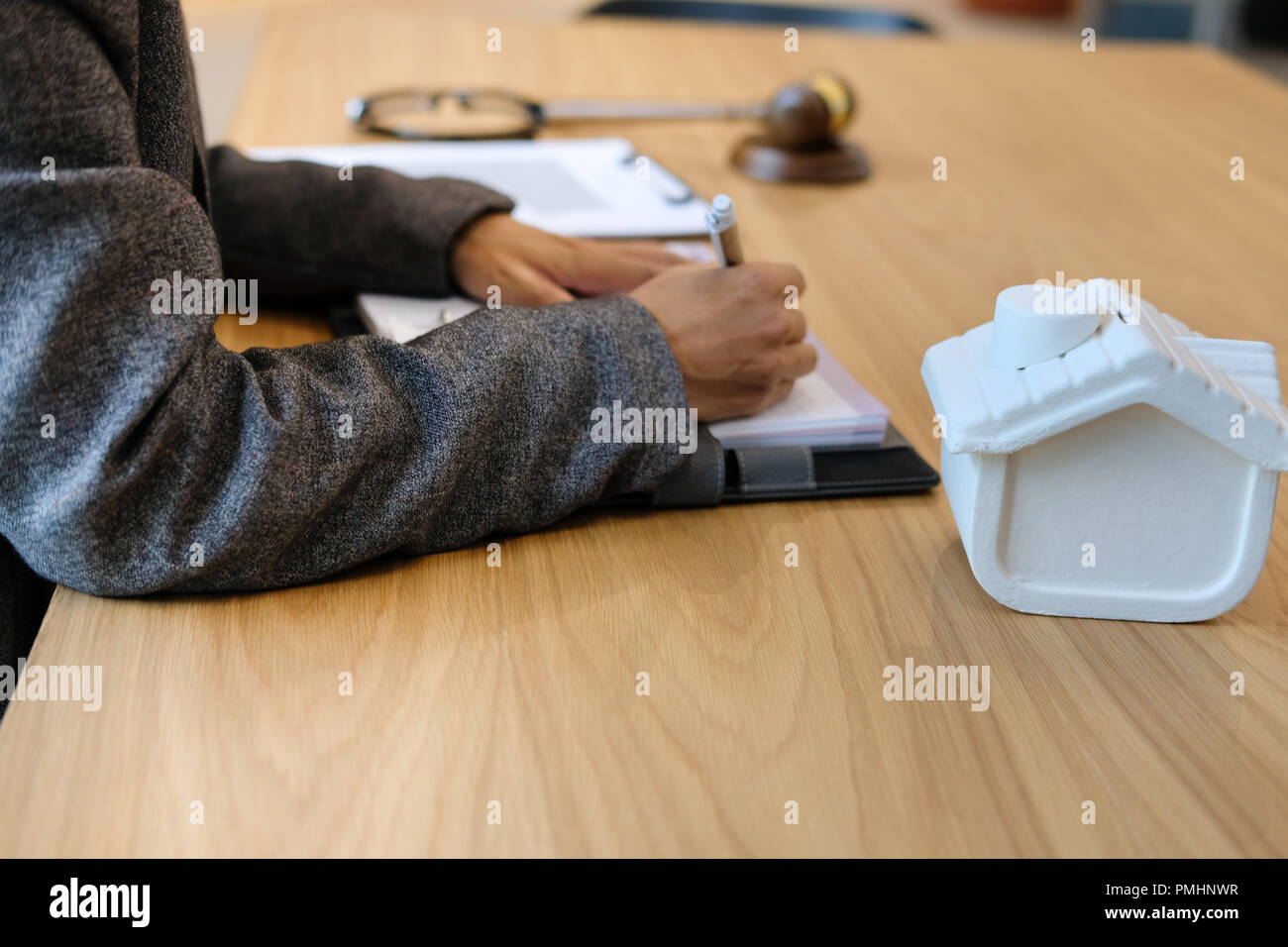 businesswoman write note with house model at law firm Stock Photo - Alamy