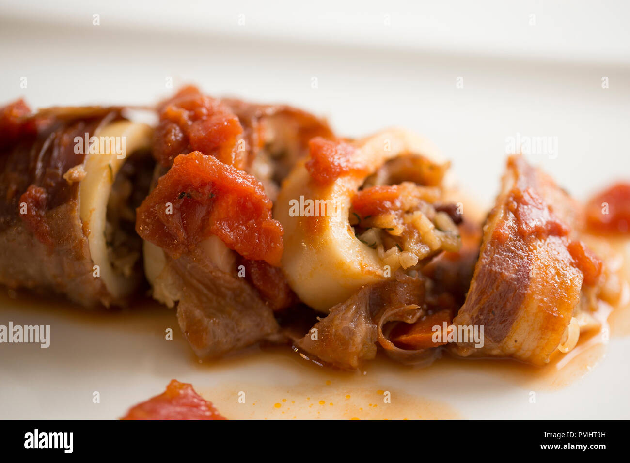 A single stuffed squid tube that has been sliced. The squid was a ...