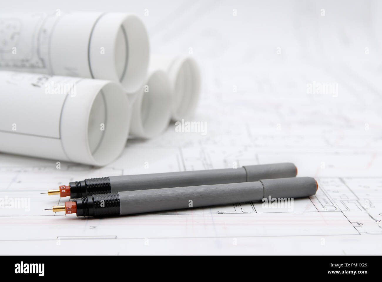 Rolled-up architectural plans and drawing utensils Stock Photo - Alamy