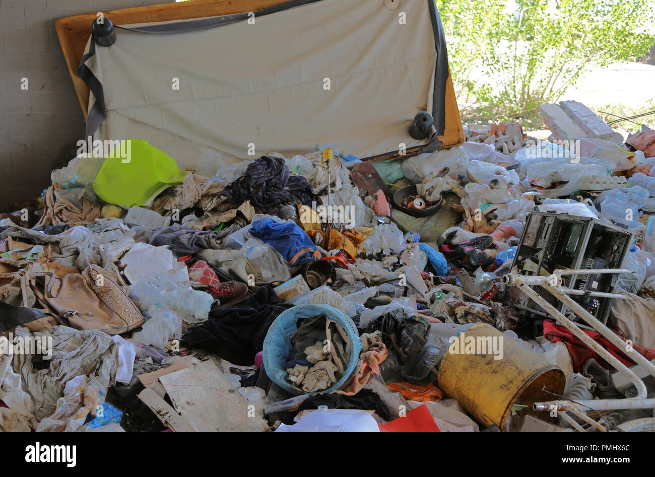 abandoned place full of dirt and waste with rags and material used by ...