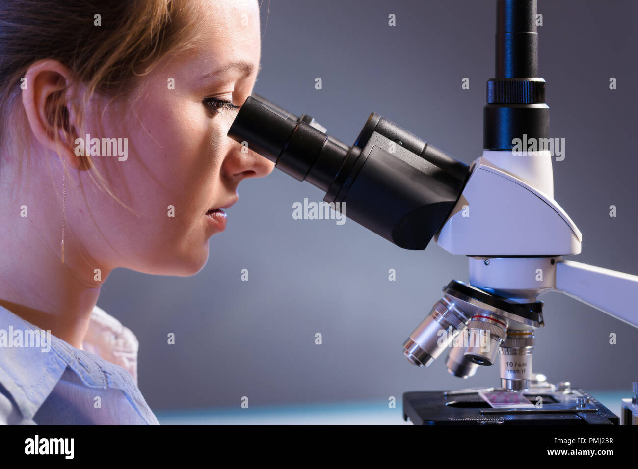 Young scientist using a microscope in a laboratory Stock Photo - Alamy
