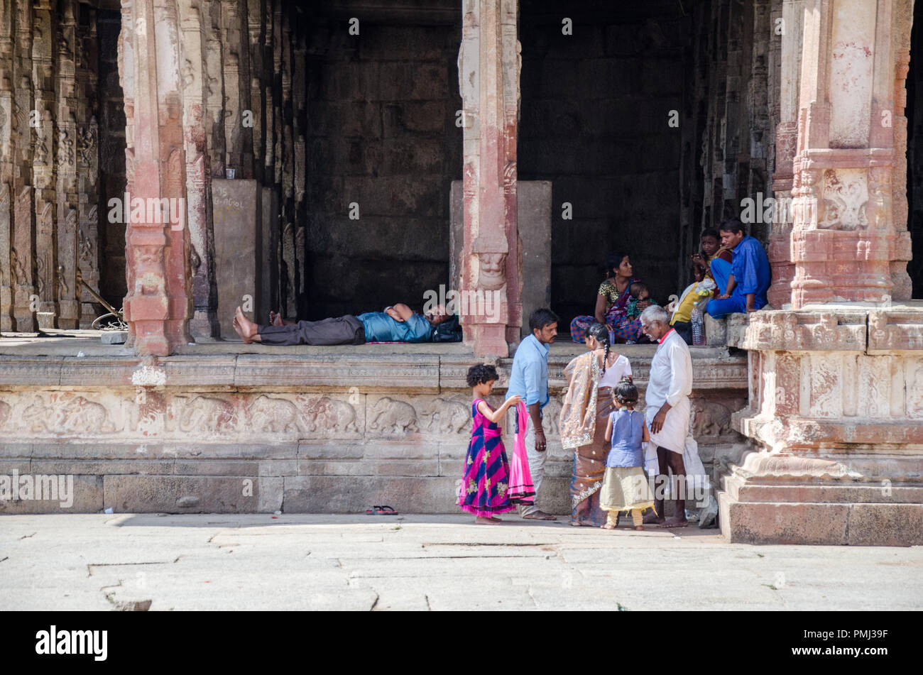 A group of people rest in the shade of one of the pillared halls at ...