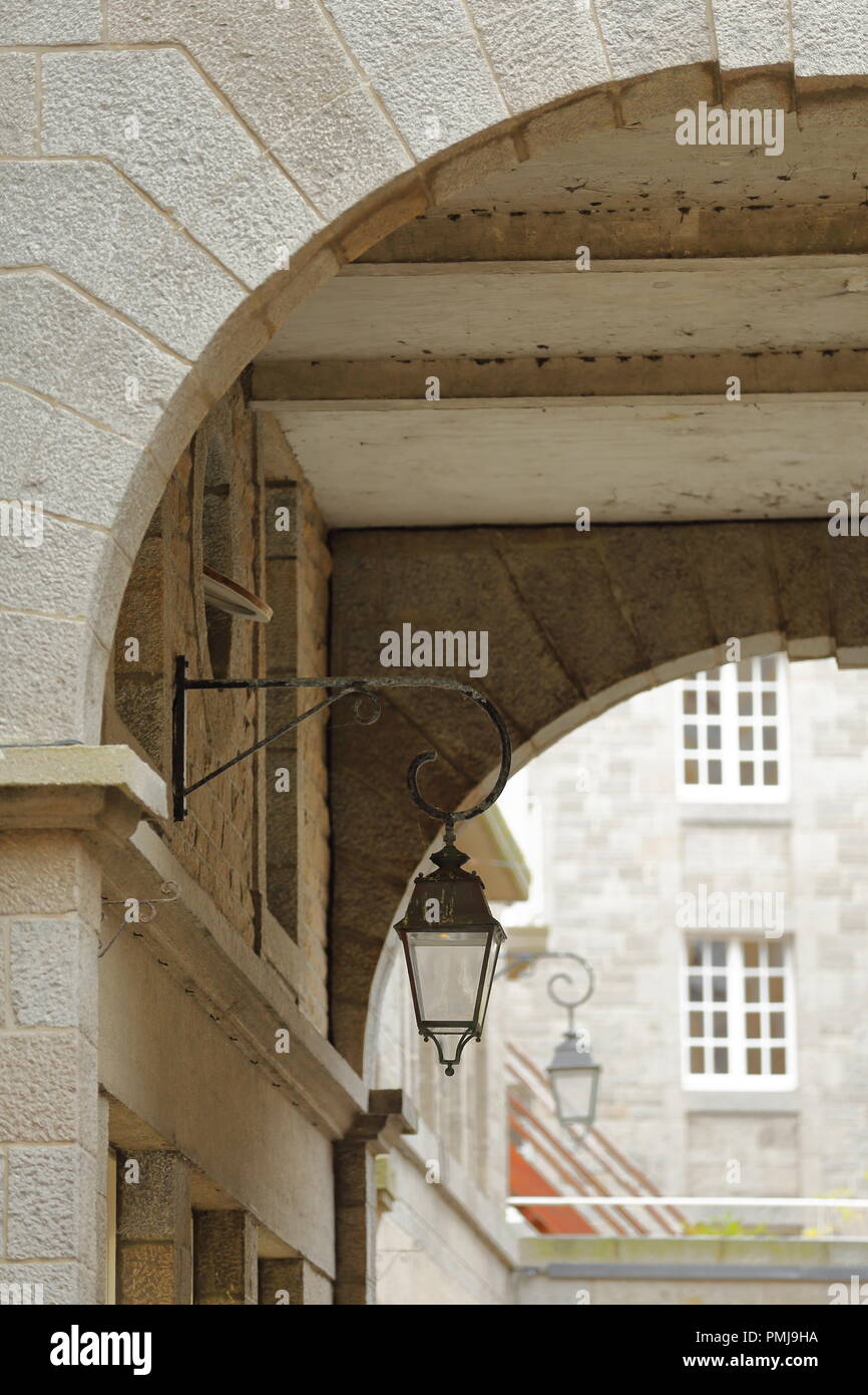 Alignment of street lamps below archways inside the walled city of ...