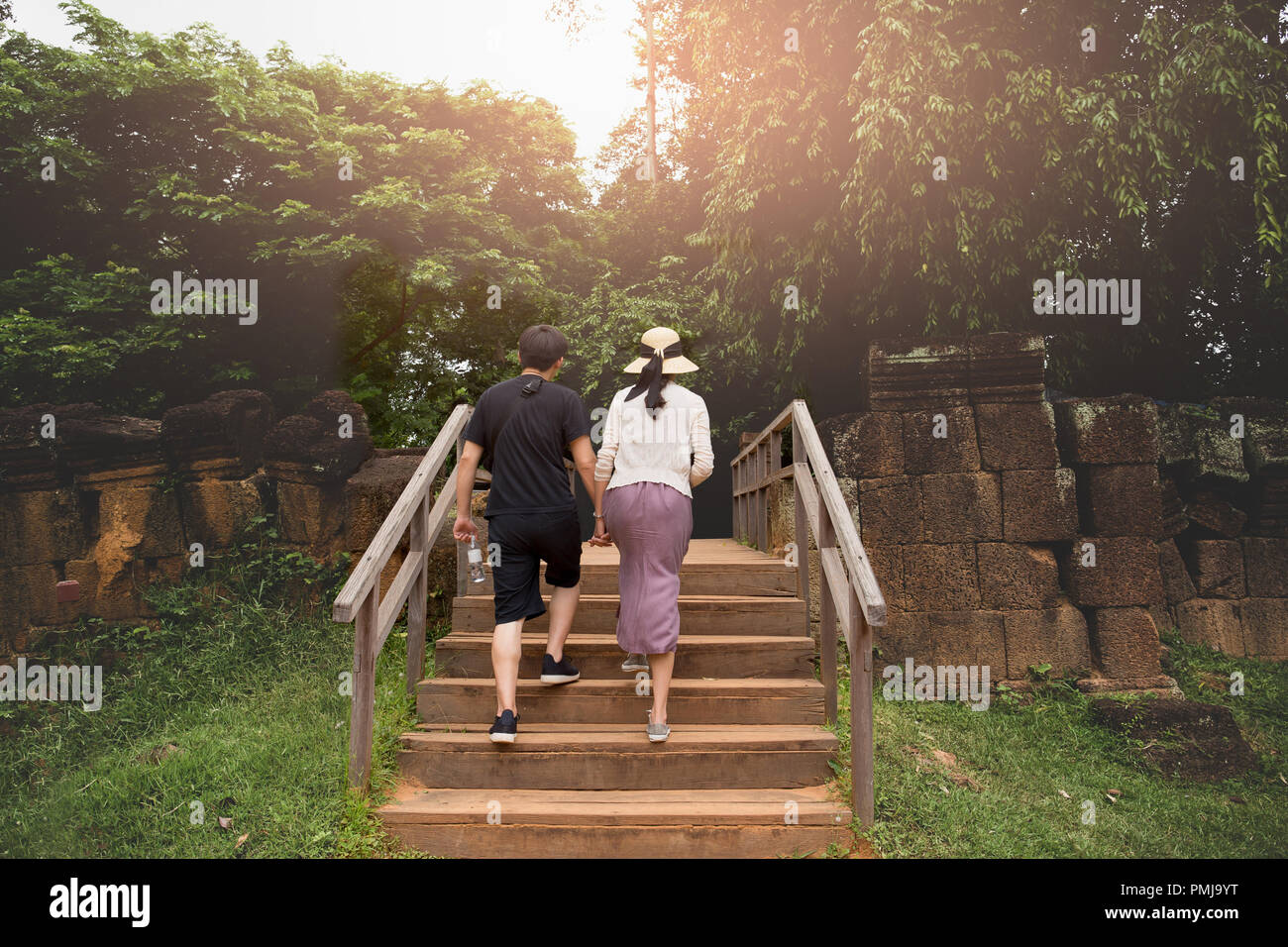 Couple Hand Holding Hand Walking Up On Wooden Stair In The Woods In