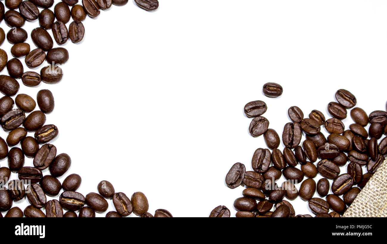 Coffee beans spread around a white surface, with copy space in the ...