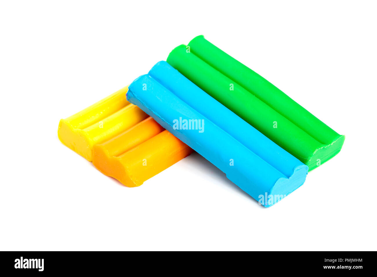 Yellow, orange, green, blue slices of plasticine on a white background ...