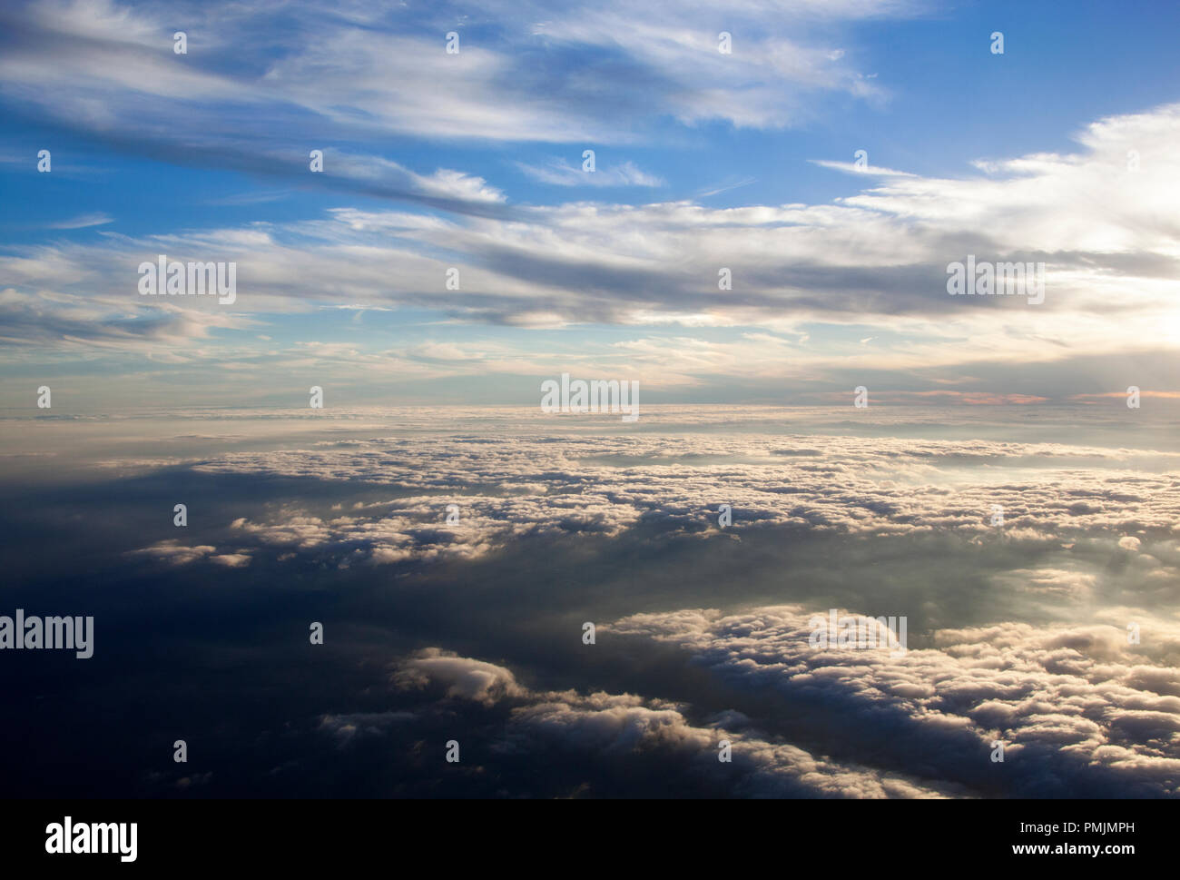 The sunset view with clouds beneath flying high over Atlantic Ocean ...