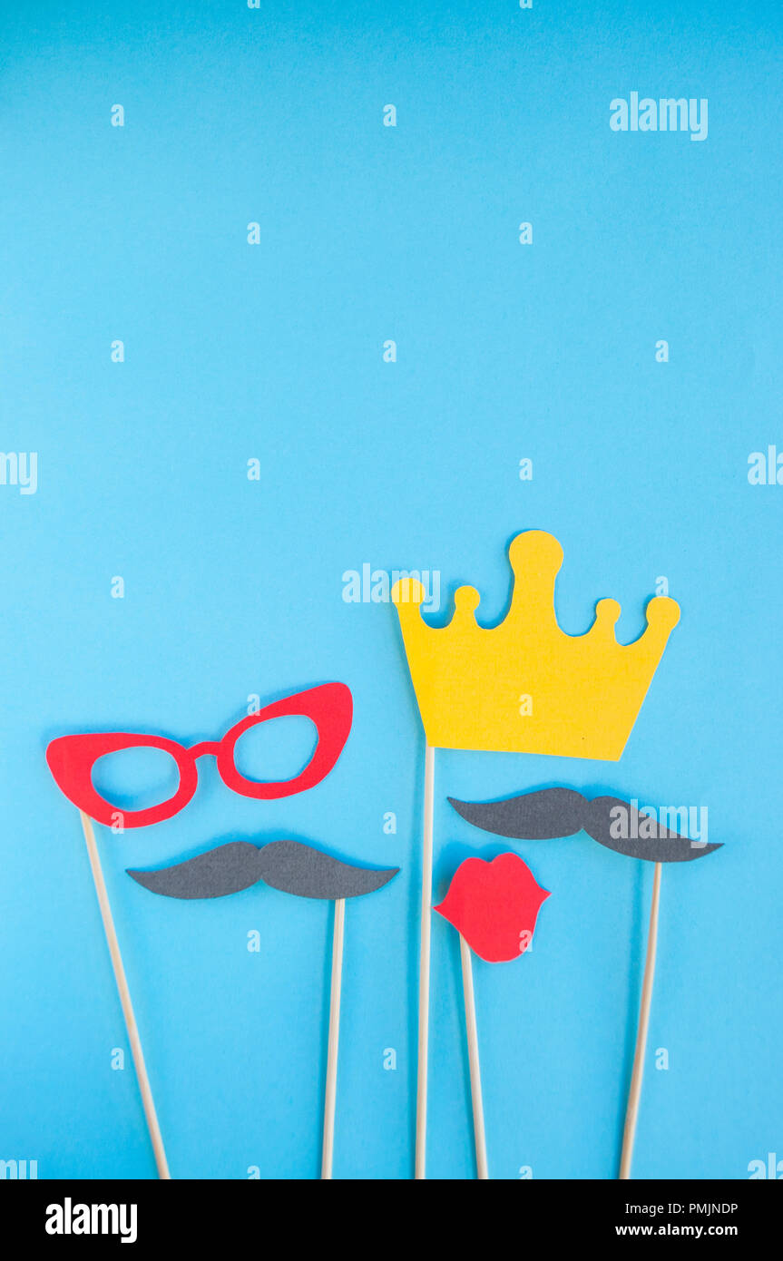 Colorful photo booth props glasses, lips, crown and moustaches on blue ...