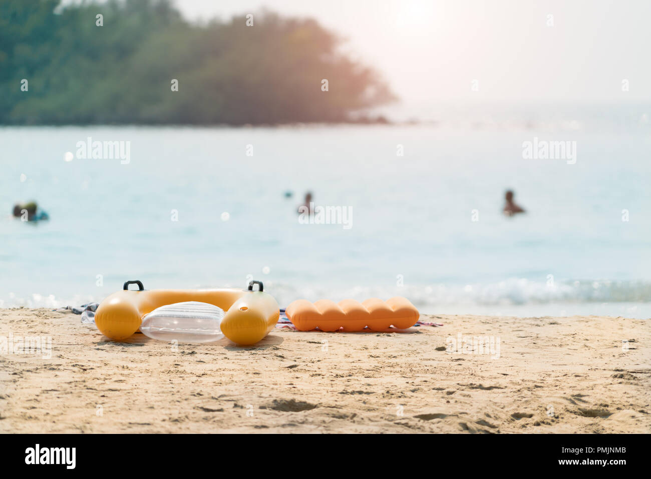 summer beach swim ring inner tube on the beach with blurred swimmer on ...