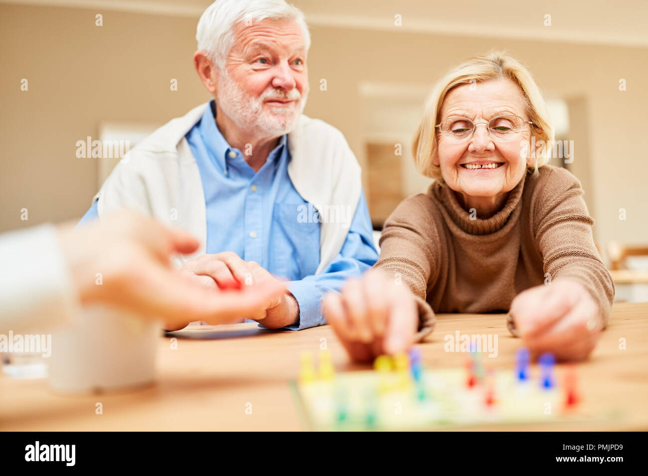Happy senior pensioner couple is having fun at board game in retirement ...