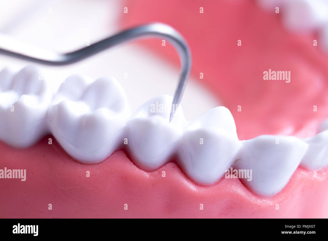 Dentist cleaning teeth with titanium metal tooth pick instrument to ...