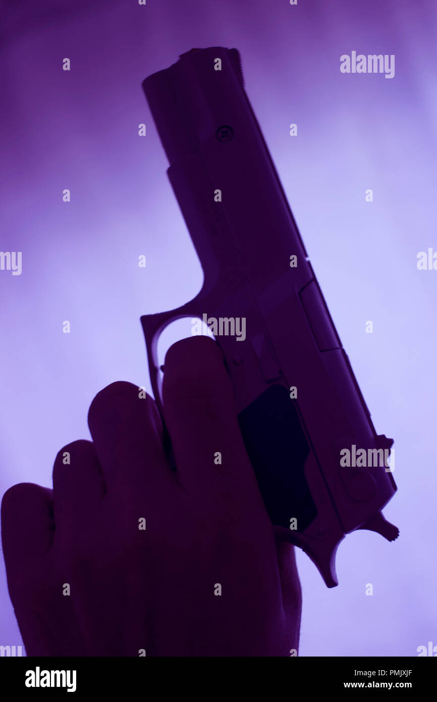 Pistol automatic handgun weapon in silhouette in hand of killer ...