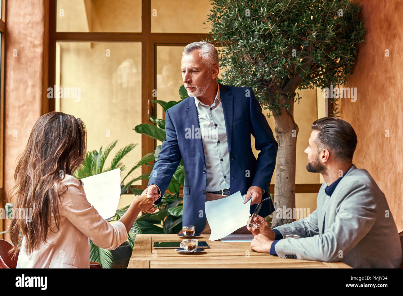 Business lunch. Three people in the restaurant sitting at table making ...