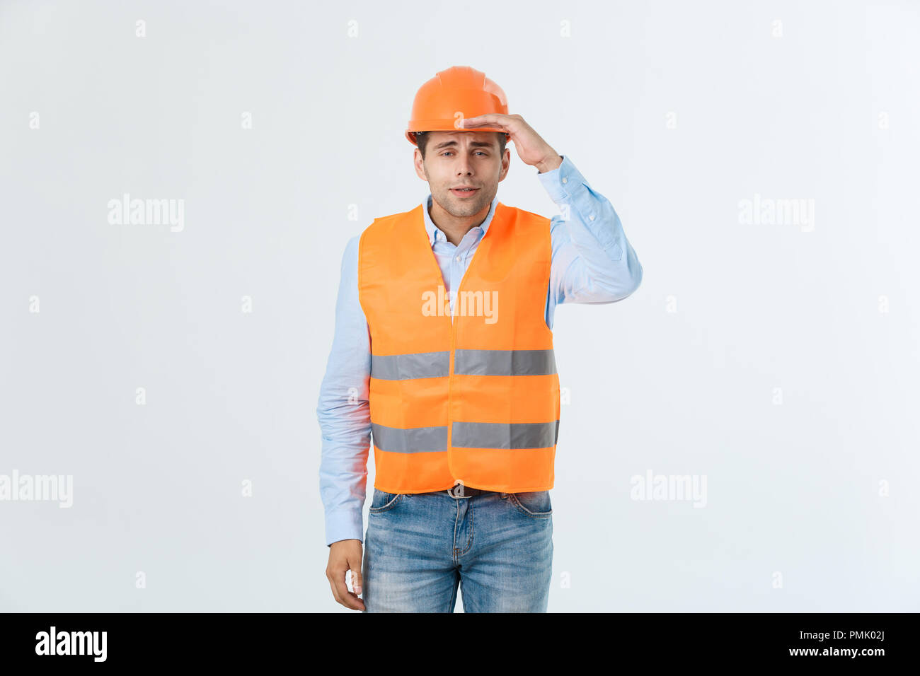 Handsome young engineer man over white background wearing safety helmet ...