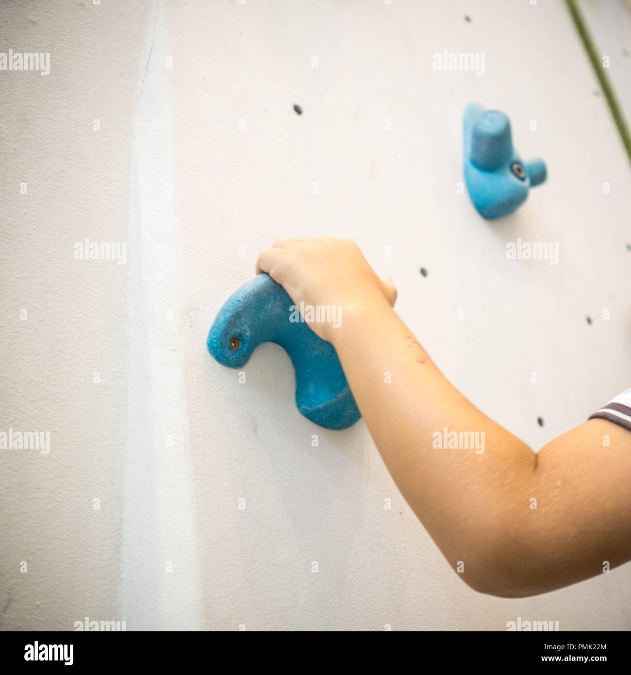 closeup of young boy's hand while climbing on artificial climbing wall ...