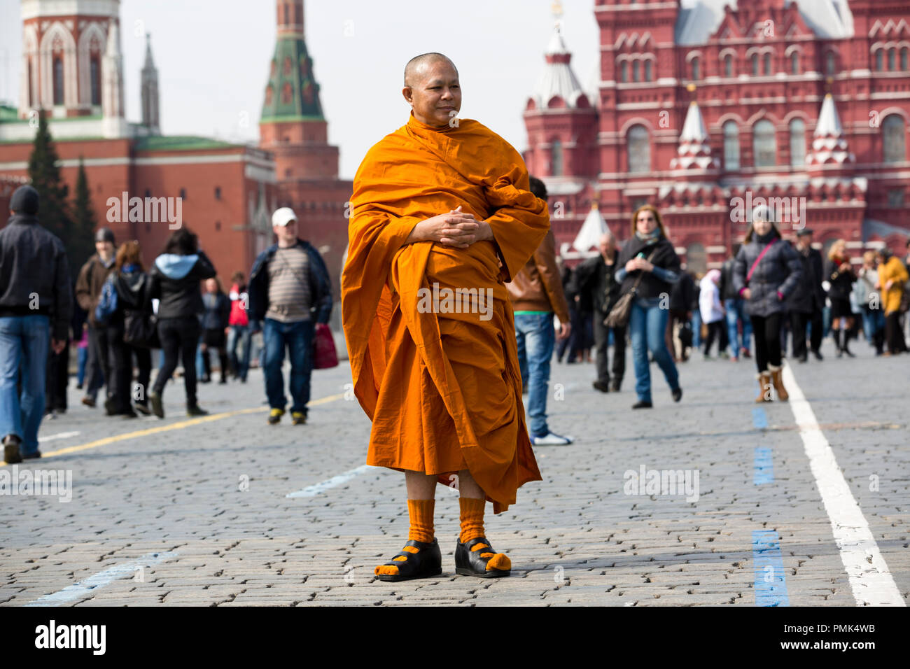 A buddhist monk walking along Red Square in the center of Moscow ...