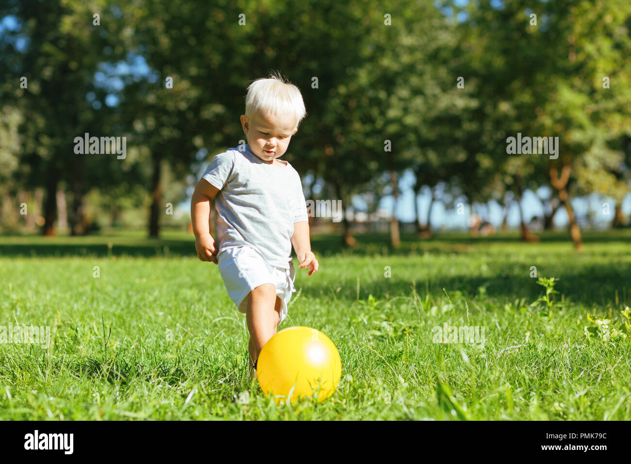 Child kicking a ball in garden hi-res stock photography and images - Alamy