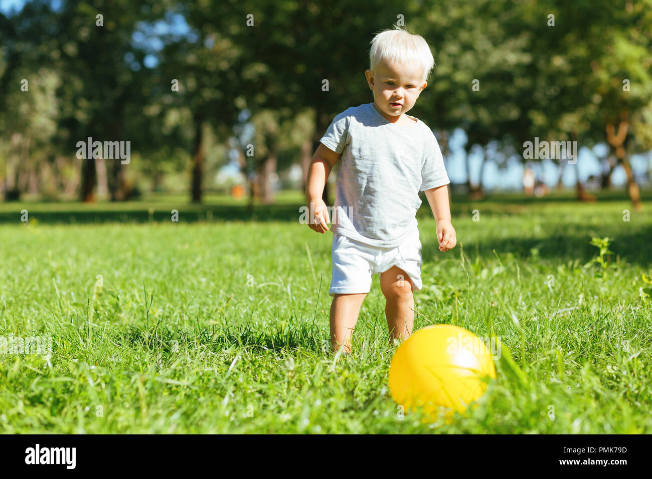 Child kicking a ball hi-res stock photography and images - Alamy