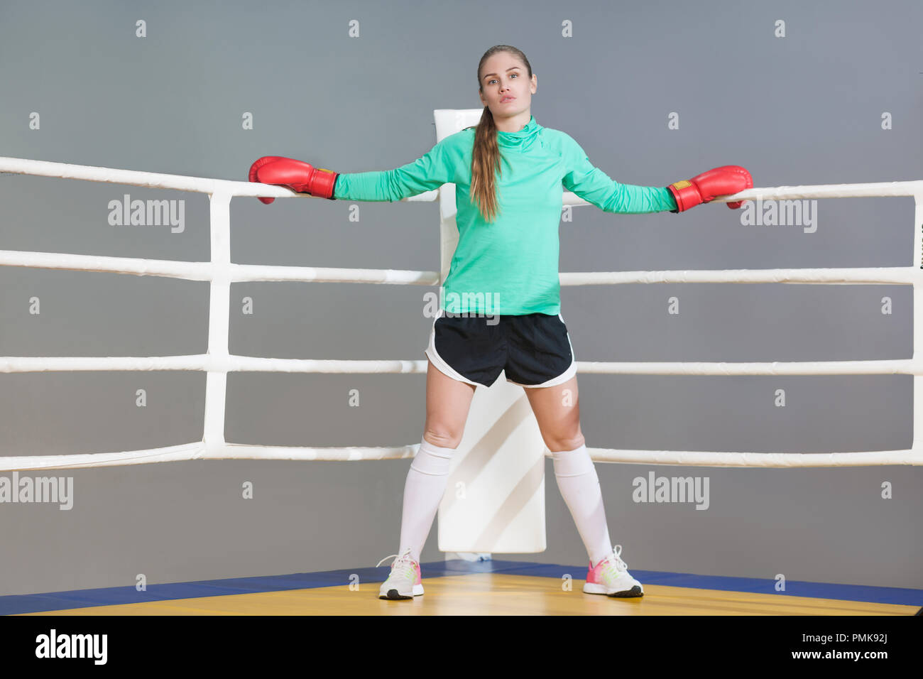 Confident beautiful young athlete woman with collected hair standing in ...