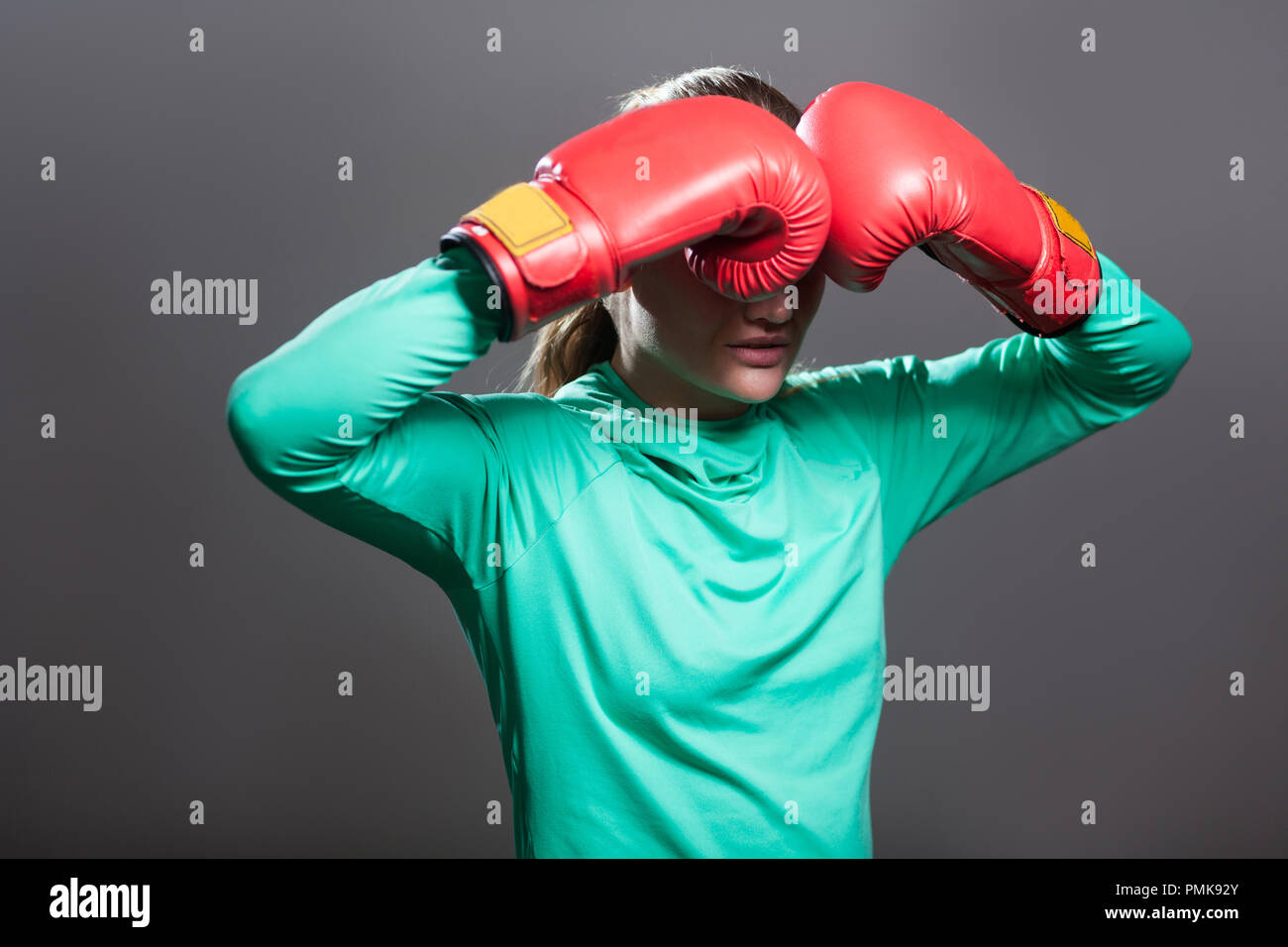 Sad young athlete woman with collected hair standing in position ...