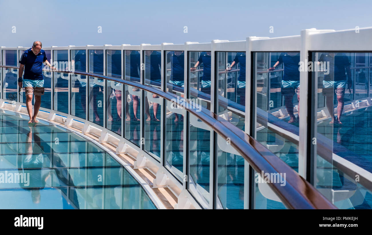 Man walking over infinity bridge surrounded by multiple reflections of ...