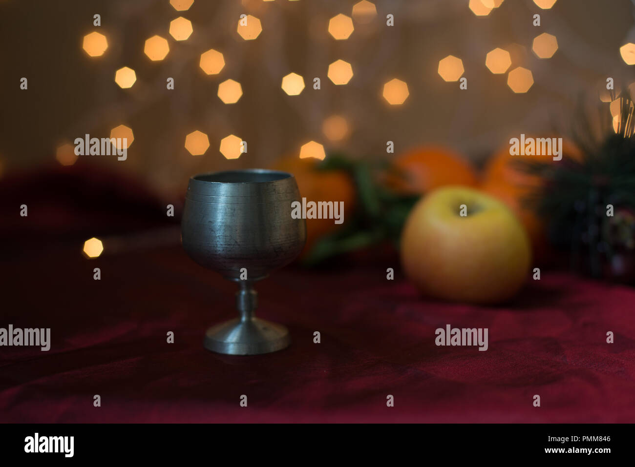 Metal cup, candle and fruit still life Stock Photo - Alamy