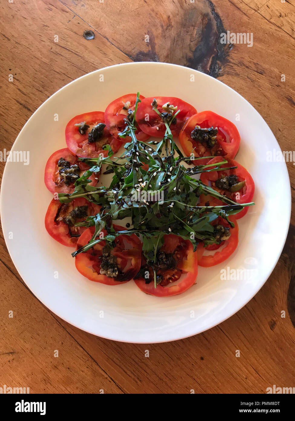 Tomato & rocket salad with olive tapenade Stock Photo - Alamy