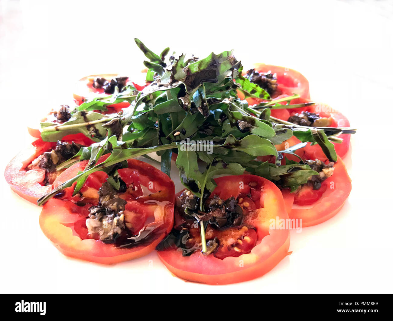 Tomato & rocket salad with olive tapenade Stock Photo - Alamy