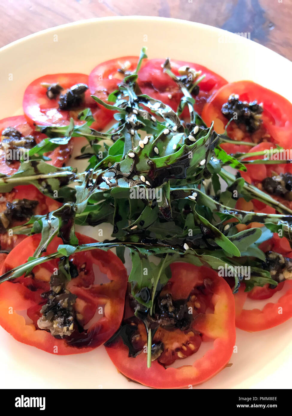 Tomato & rocket salad with olive tapenade Stock Photo - Alamy