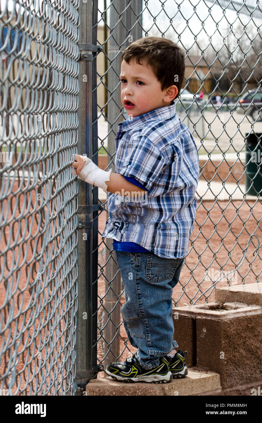 Child behind a metal fence at a baseball game Stock Photo - Alamy