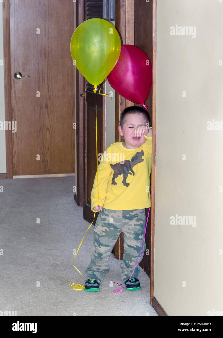 crying little boy with balloons at a party Stock Photo - Alamy