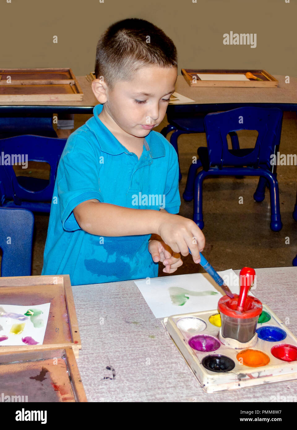 Little boy creating art in a class room Stock Photo - Alamy