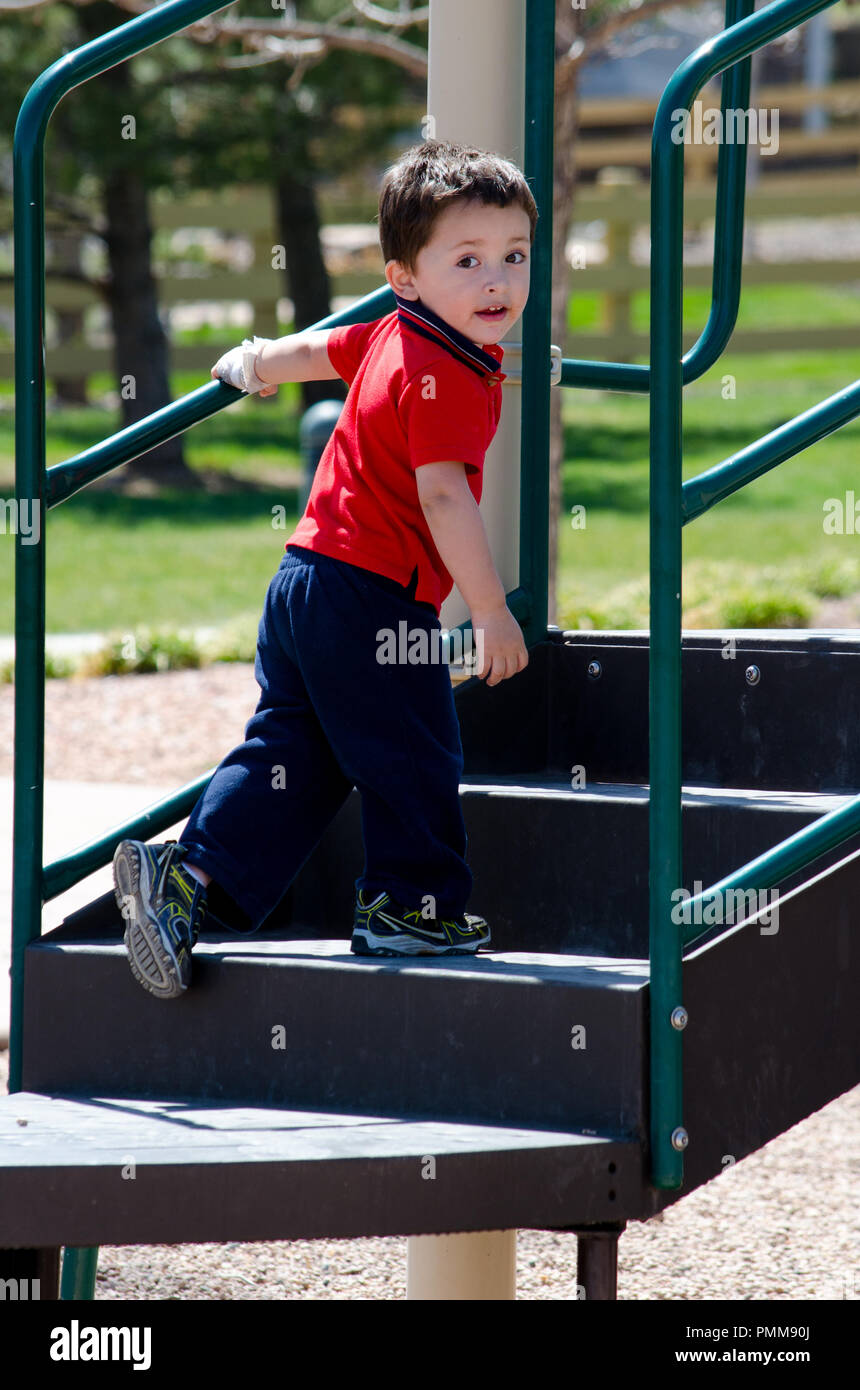 Toddler climbing up steps, making sure mom is watching Stock Photo - Alamy