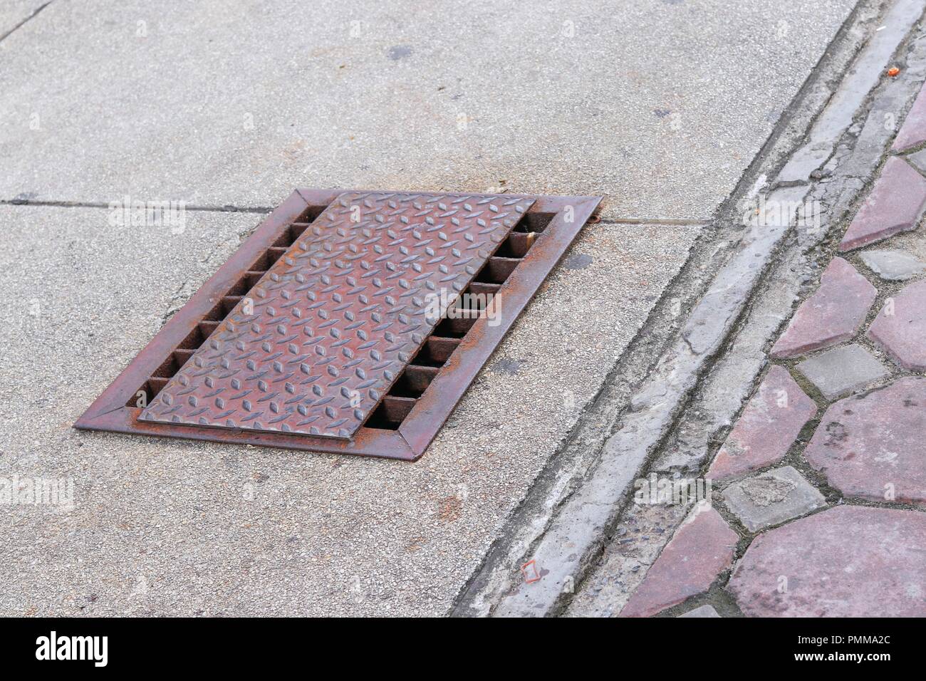 steel lid old water drain or ditch on the road Stock Photo - Alamy
