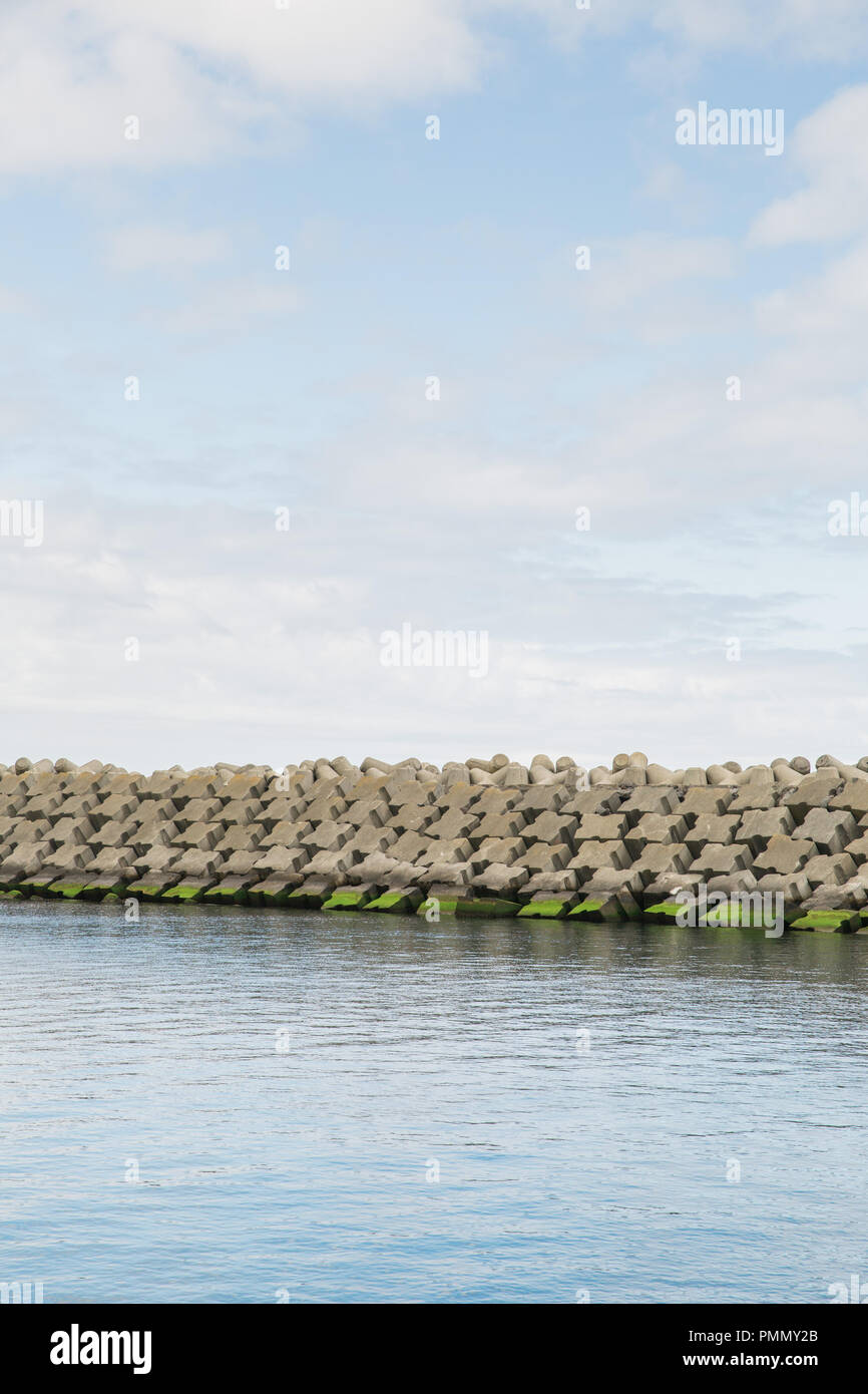 Manmade sea wall / defence / barrier built with blocks of cross-shaped ...