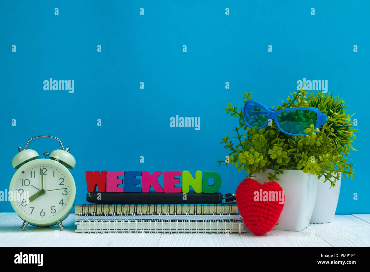 WEEKEND letters text and notebook paper, alarm clock and little ...