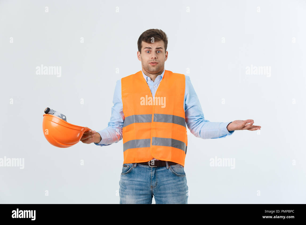Handsome young engineer man over white background wearing safety helmet ...