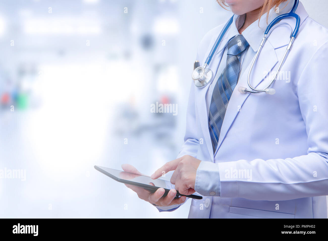 smart woman doctor holding tablet and pointing to screen on blurry out ...