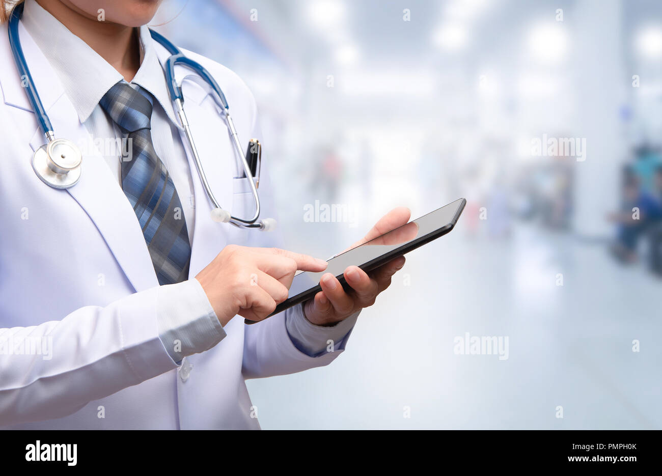smart woman doctor holding tablet and pointing to screen on blurry out ...