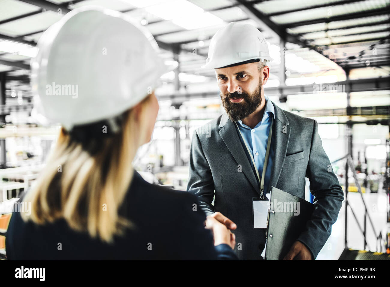 A portrait of an industrial man and woman engineer in a factory ...