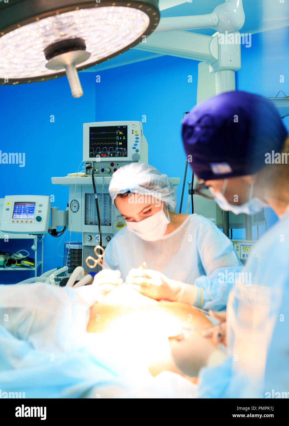 Surgery, medicine and people concept - three surgeons in operating room ...