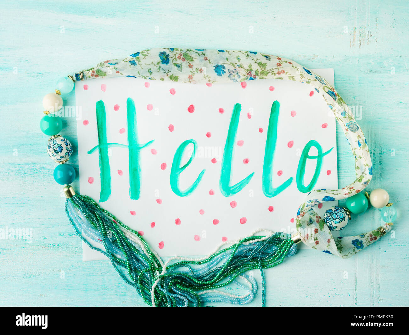 Hello card on pastel turquoise background with necklace Stock Photo - Alamy